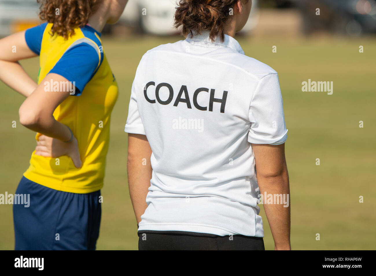 Back of sport coach wearing COACH shirt at an outdoor sport field ...