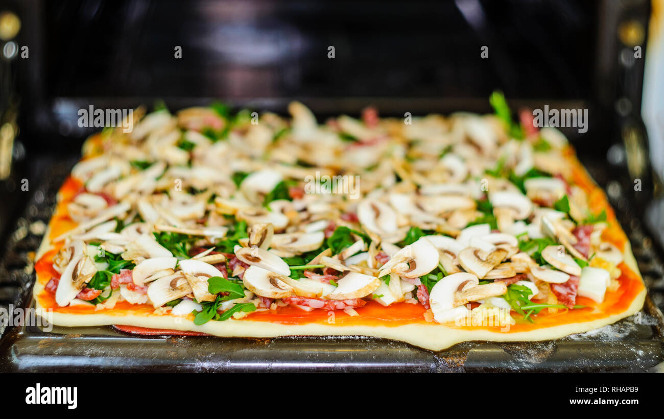 Process of making pizza. Italian pepperoni pizza with mushrooms ...