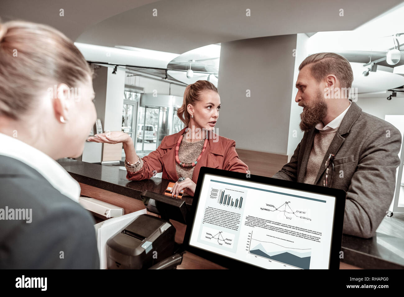 Positive delighted manager looking at her clients Stock Photo - Alamy