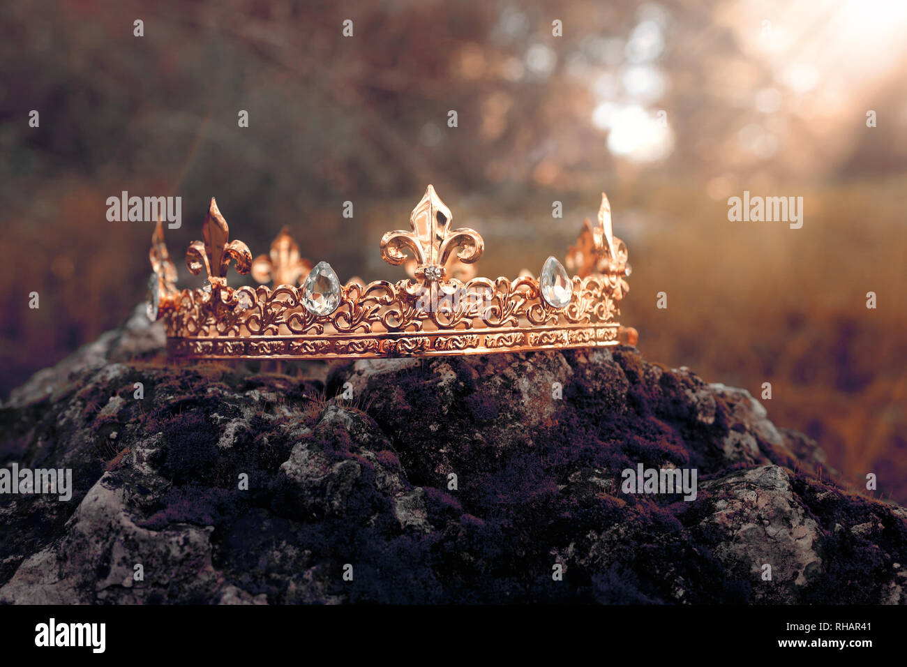 mysterious and magical photo of gold king crown over the stone covered ...