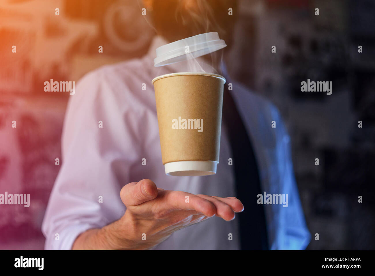 Barista in a white shirt with a tie holds floating in the air a paper ...
