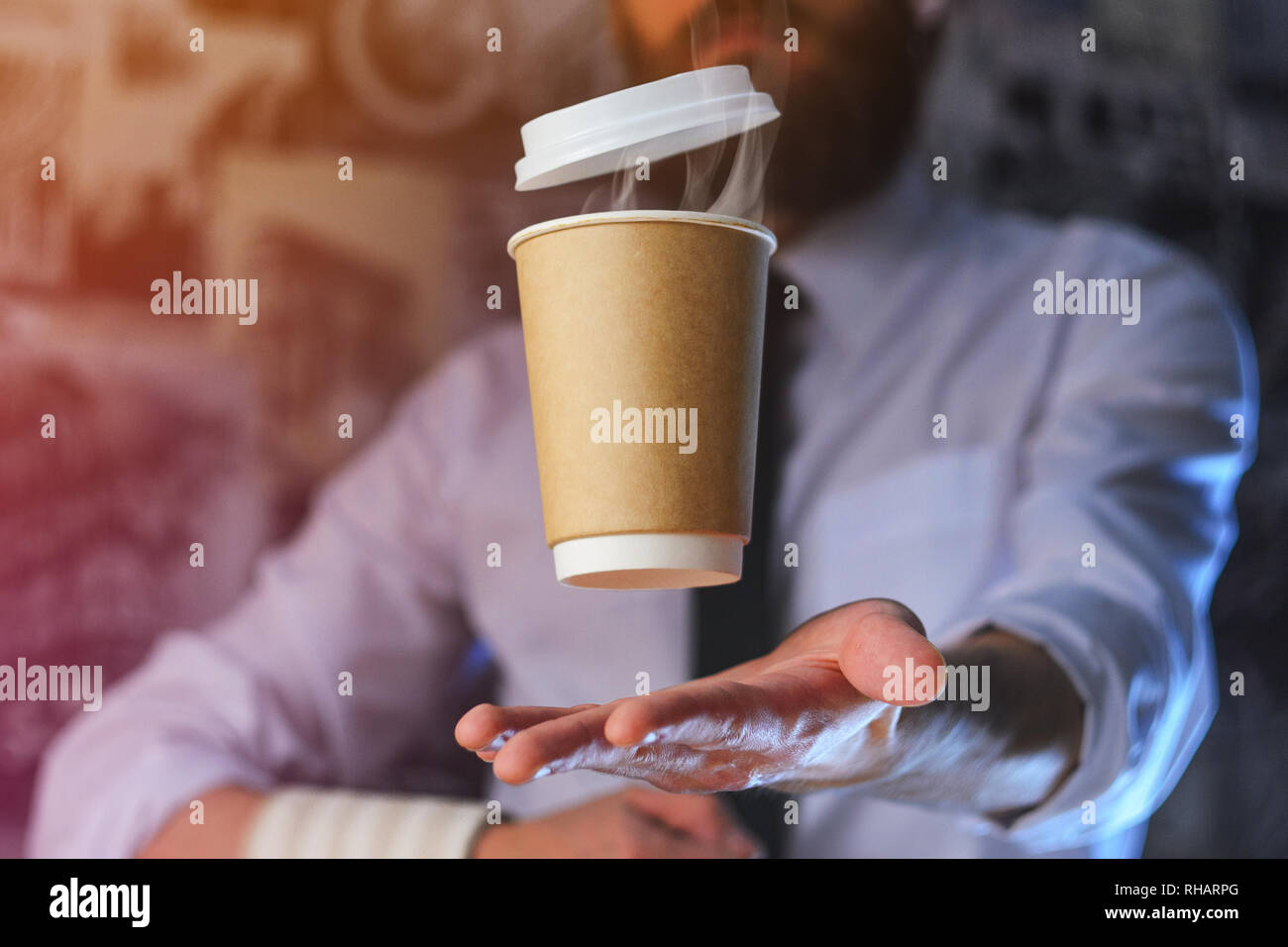 Barista in a white shirt with a tie holds floating in the air a paper ...