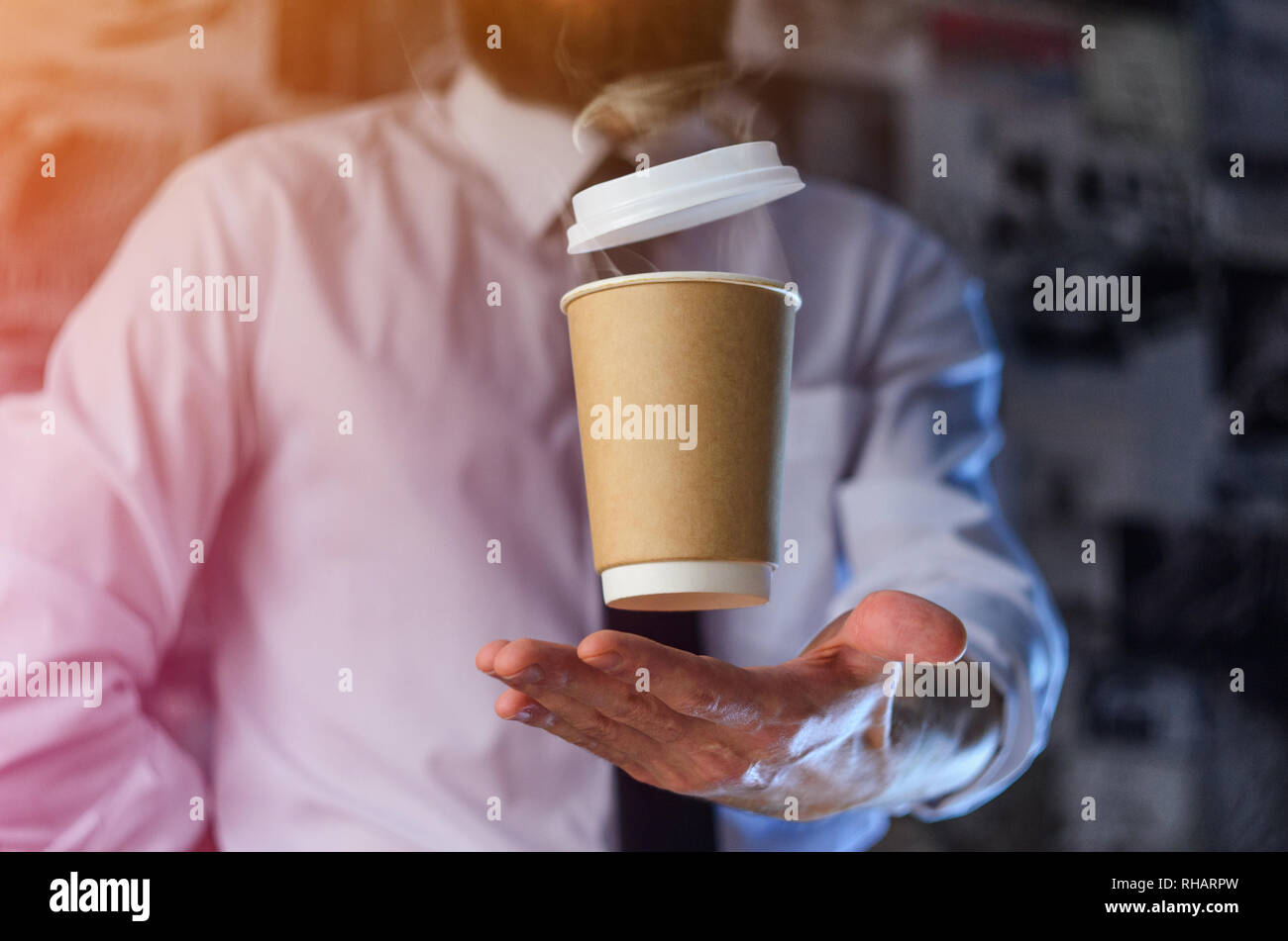 Barista in a white shirt with a tie holds floating in the air a paper ...
