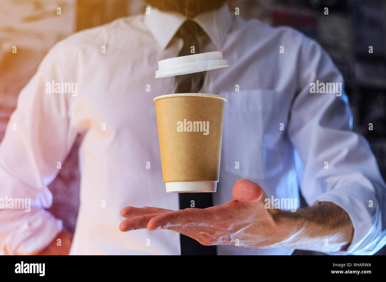 Barista in a white shirt with a tie holds floating in the air a paper ...