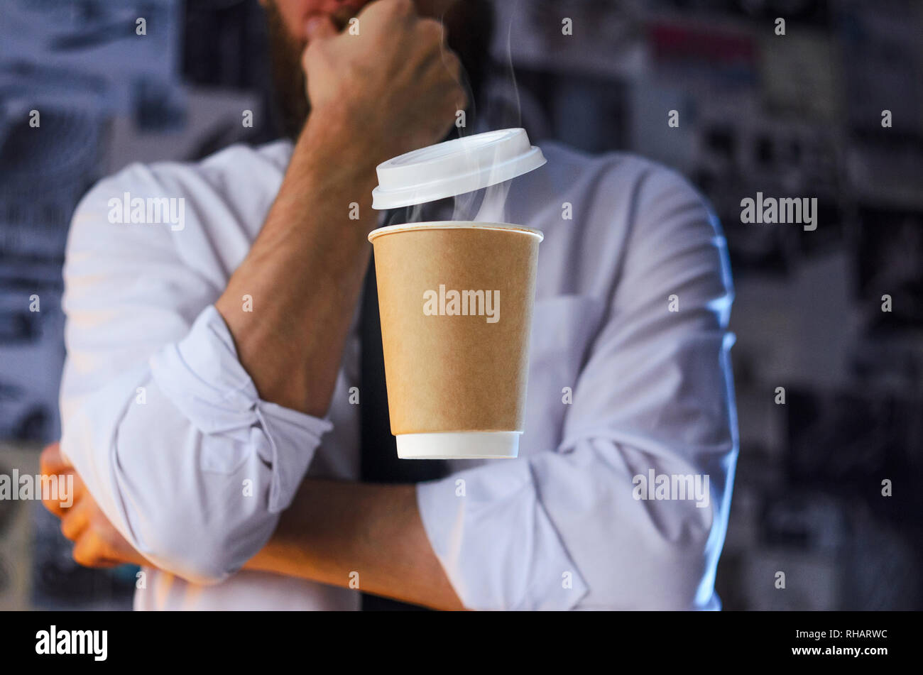 Meditative barista in a white shirt and tie and levitating paper cup of ...