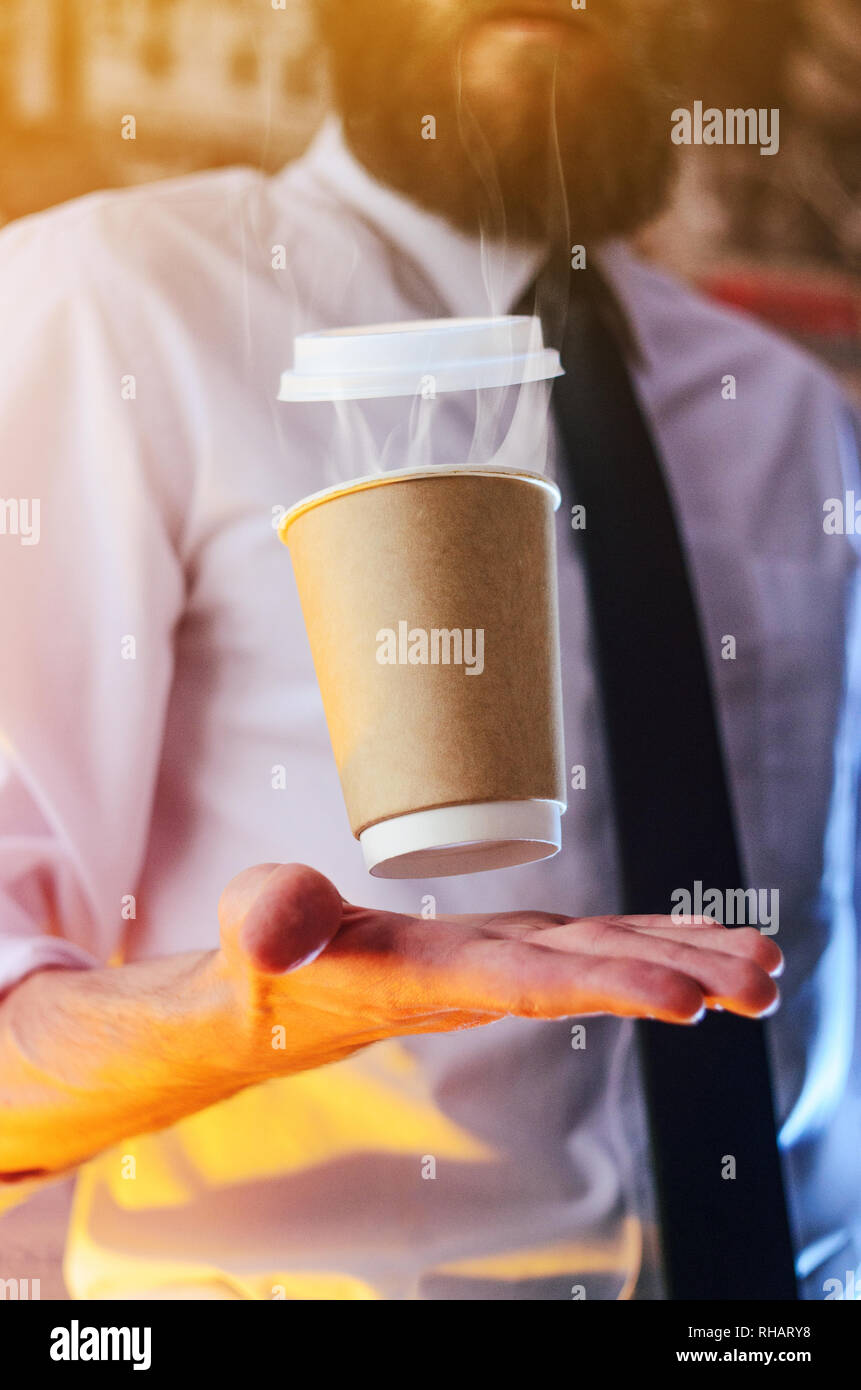 Barista in a white shirt with a tie holds floating in the air a paper ...