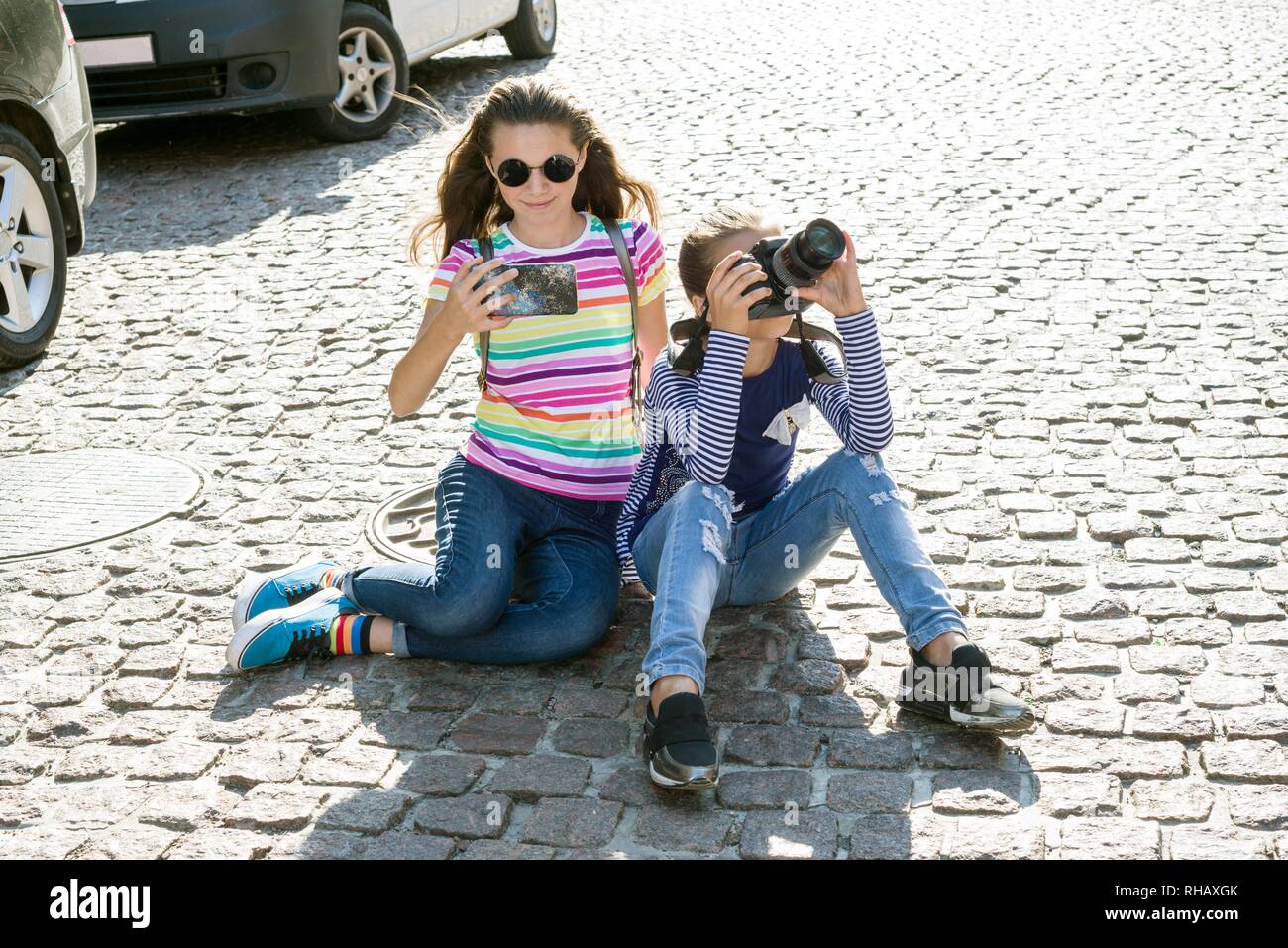 Cute teen girls use a camera and a smartphone for a photo Stock Photo ...