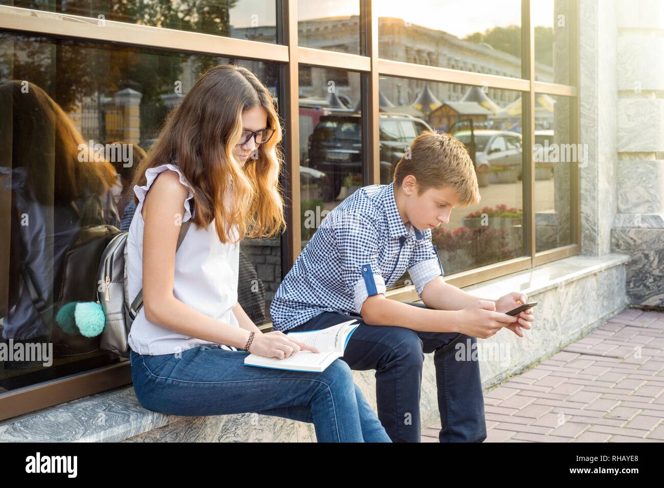 Children teenagers, reading book and using smartphone Stock Photo - Alamy