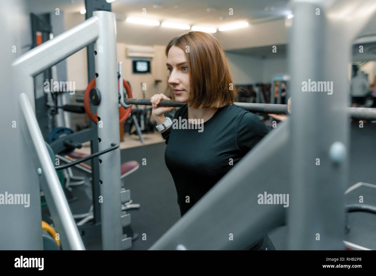 Young strong fitness woman doing strength exercises with heavy weight ...