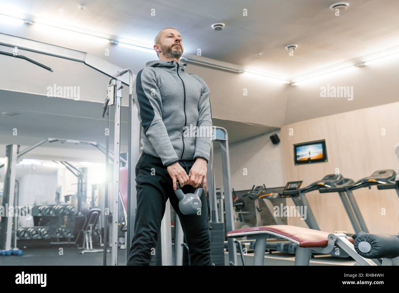 Adult handsome bearded man doing physical exercises in the gym. Sport ...