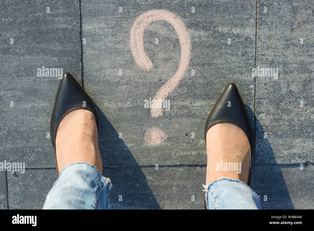 Woman feet with question mark in front of her legs painted on the ...