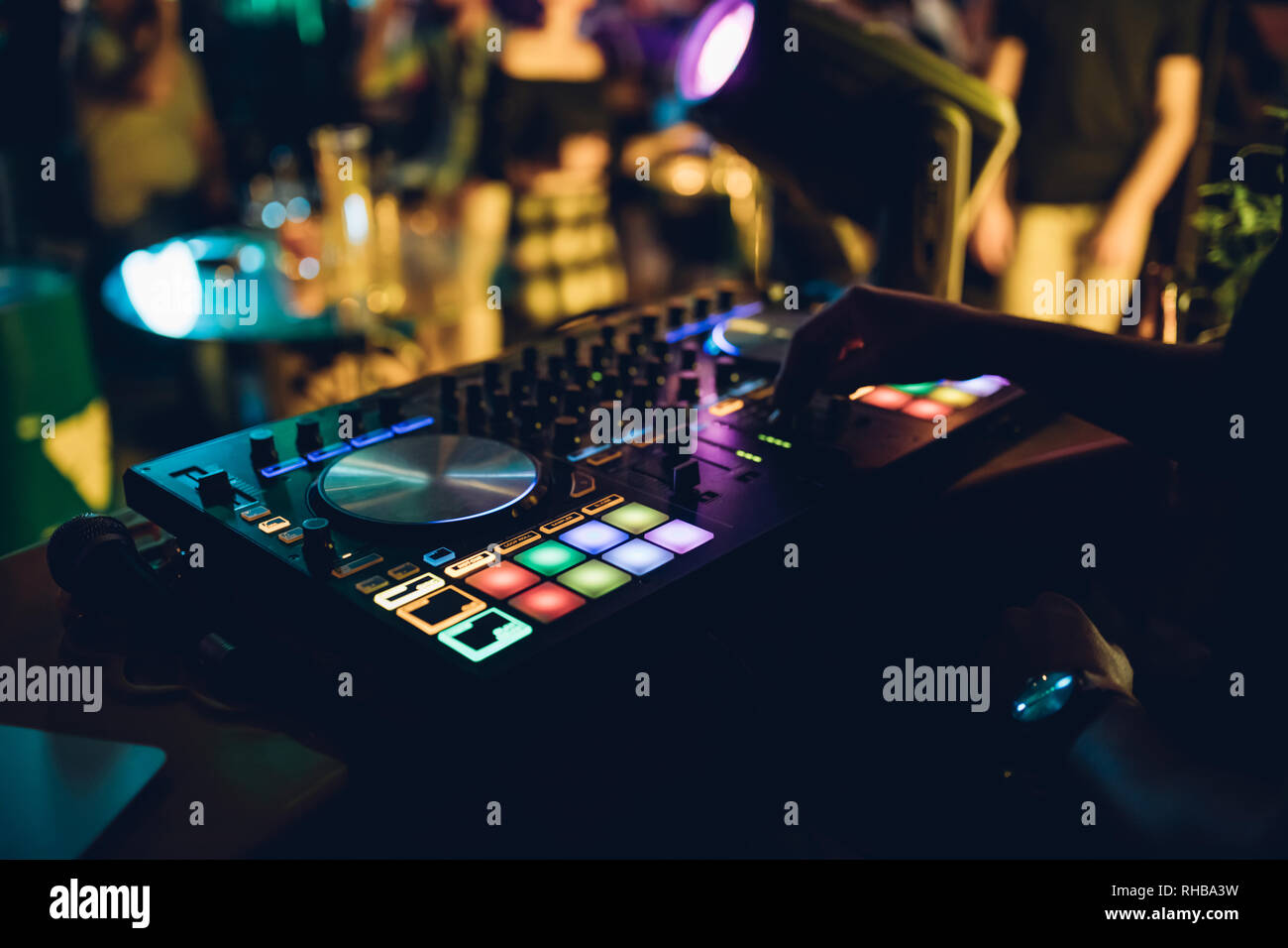 DJ plays live set and mixing music on turntable console at stage in the ...