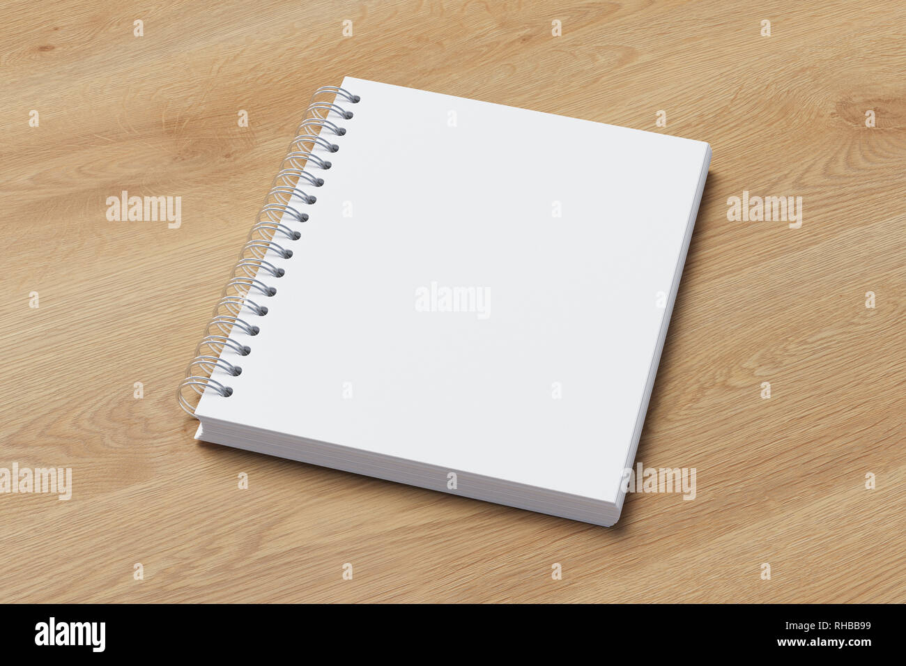 Blank vertical spiral notepad on wooden background. With clipping path ...