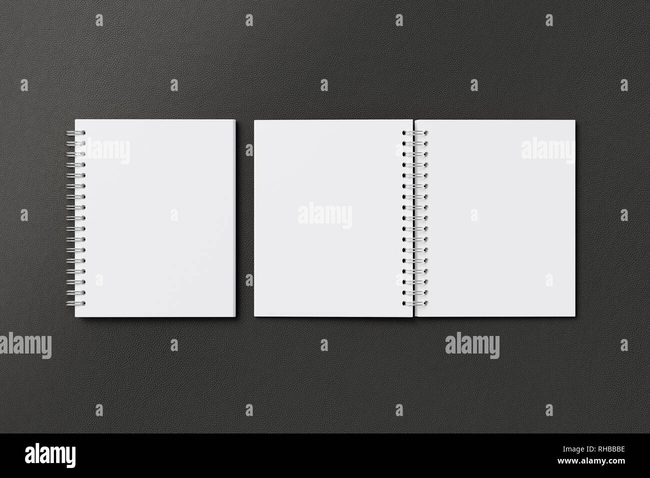 Blank open and closed vertical spiral notepads on black background ...