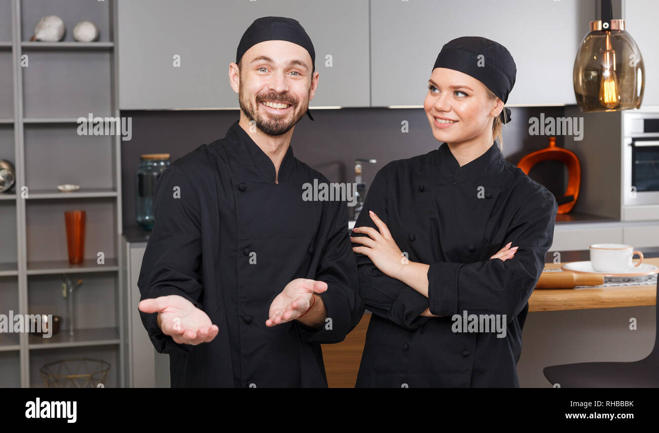 Portrait of two confident personal chefs standing in modern interior of ...