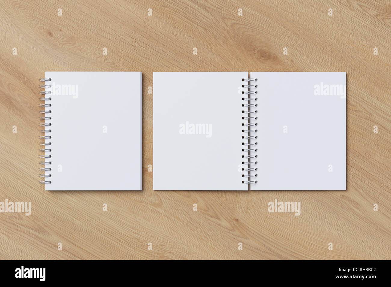 Blank open and closed vertical spiral notepads on wooden background ...