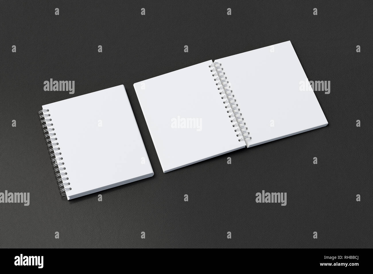 Blank open and closed vertical spiral notepads on black background ...