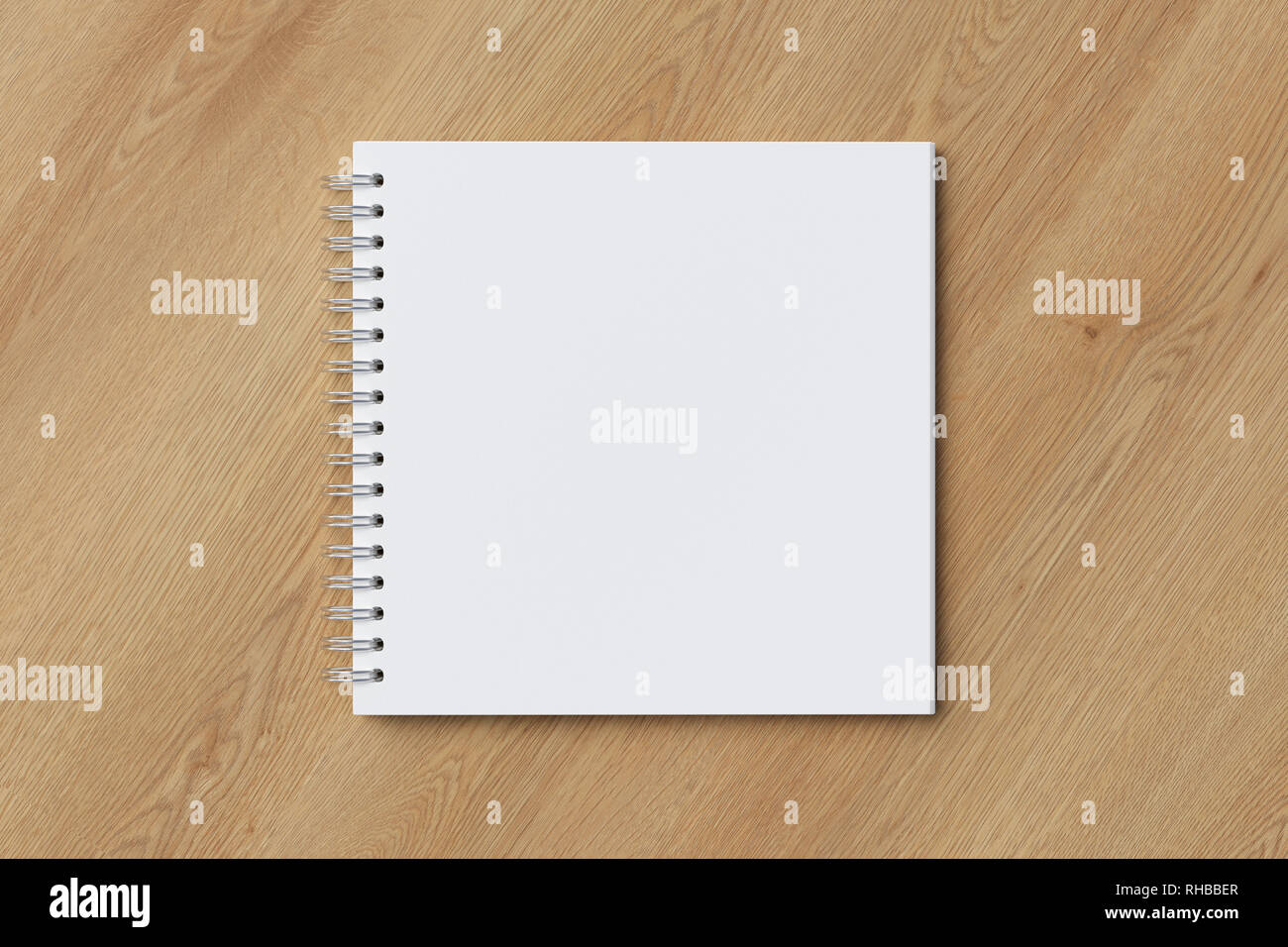 Blank square spiral notepad on wooden background. With clipping path ...