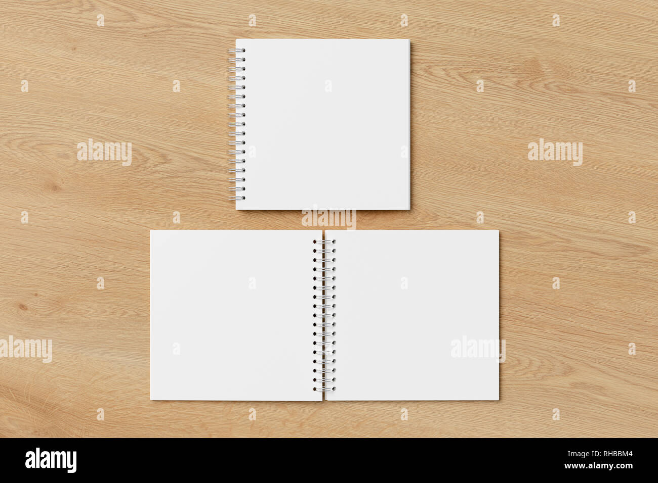 Blank open and closed square spiral notepad on wooden background. With ...
