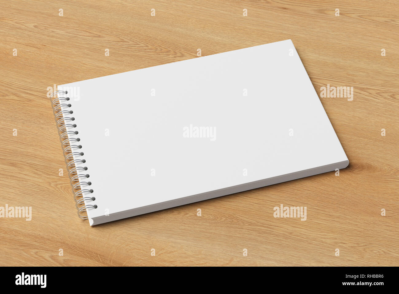Blank horizontal spiral notepad on wooden background. With clipping ...