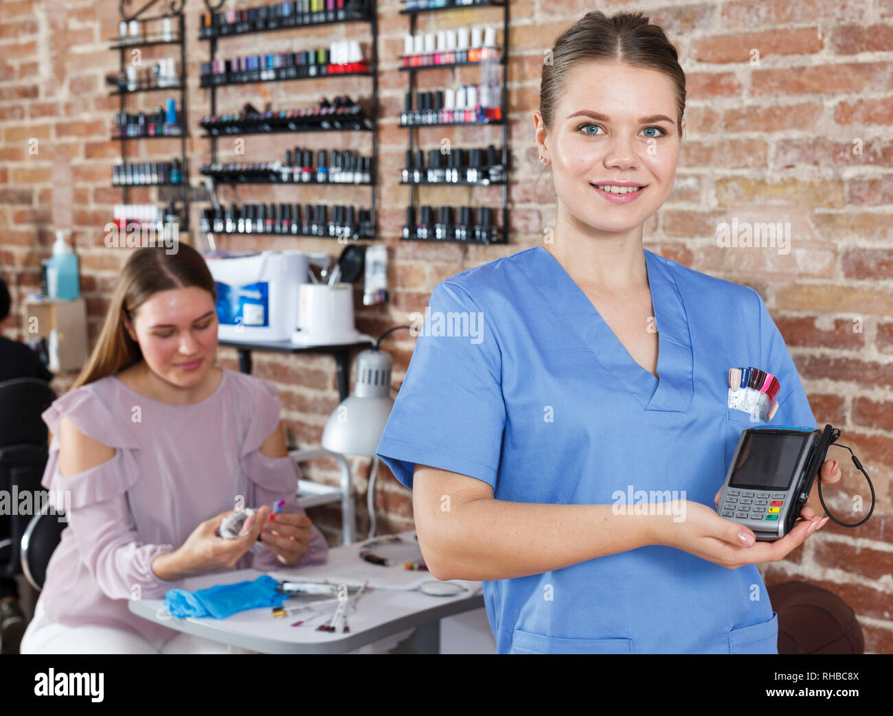 Manicure salon worker girl helping to client with payments in salon ...