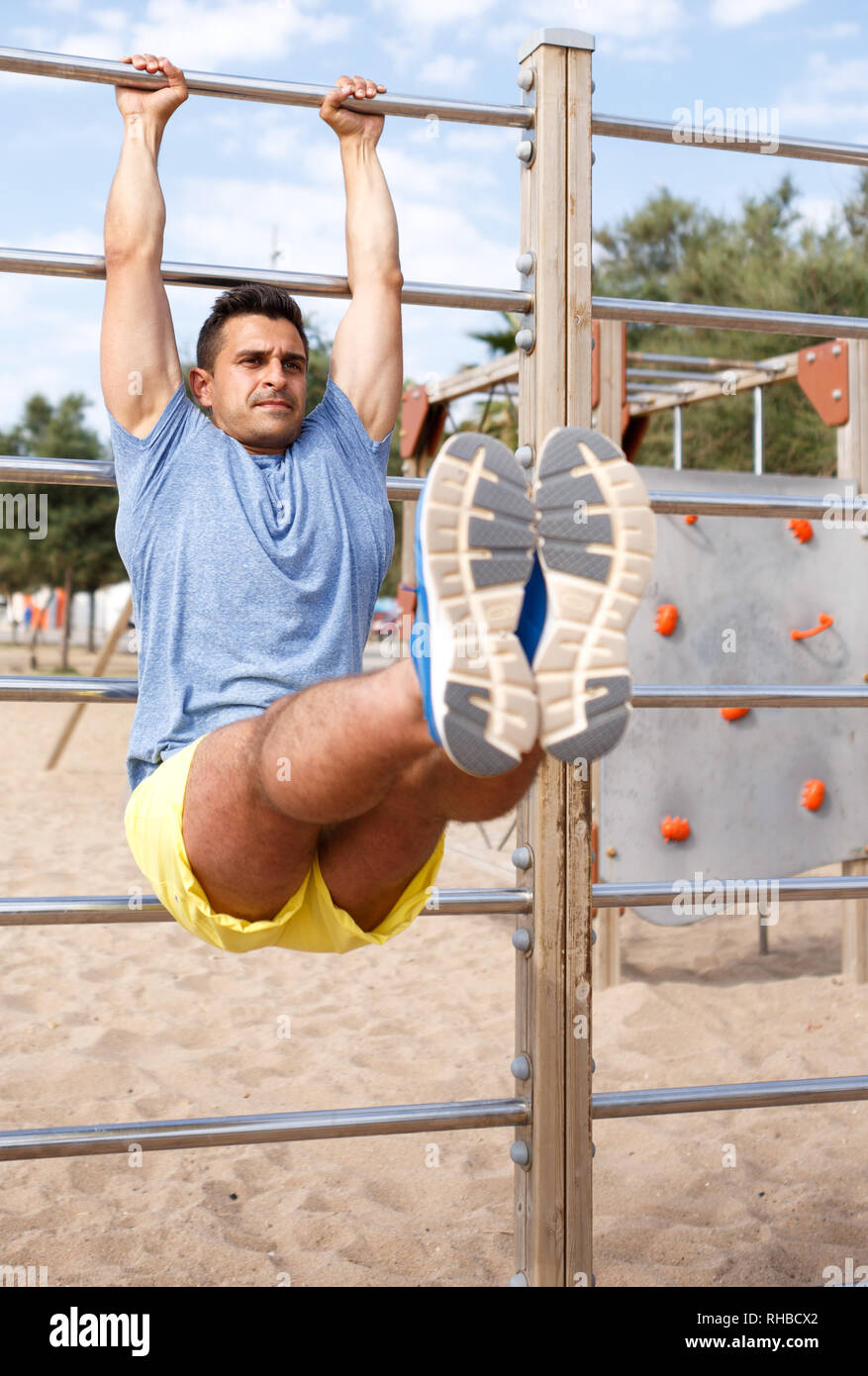 Young positive man practicing healthy lifestyle, doing exercises at ...