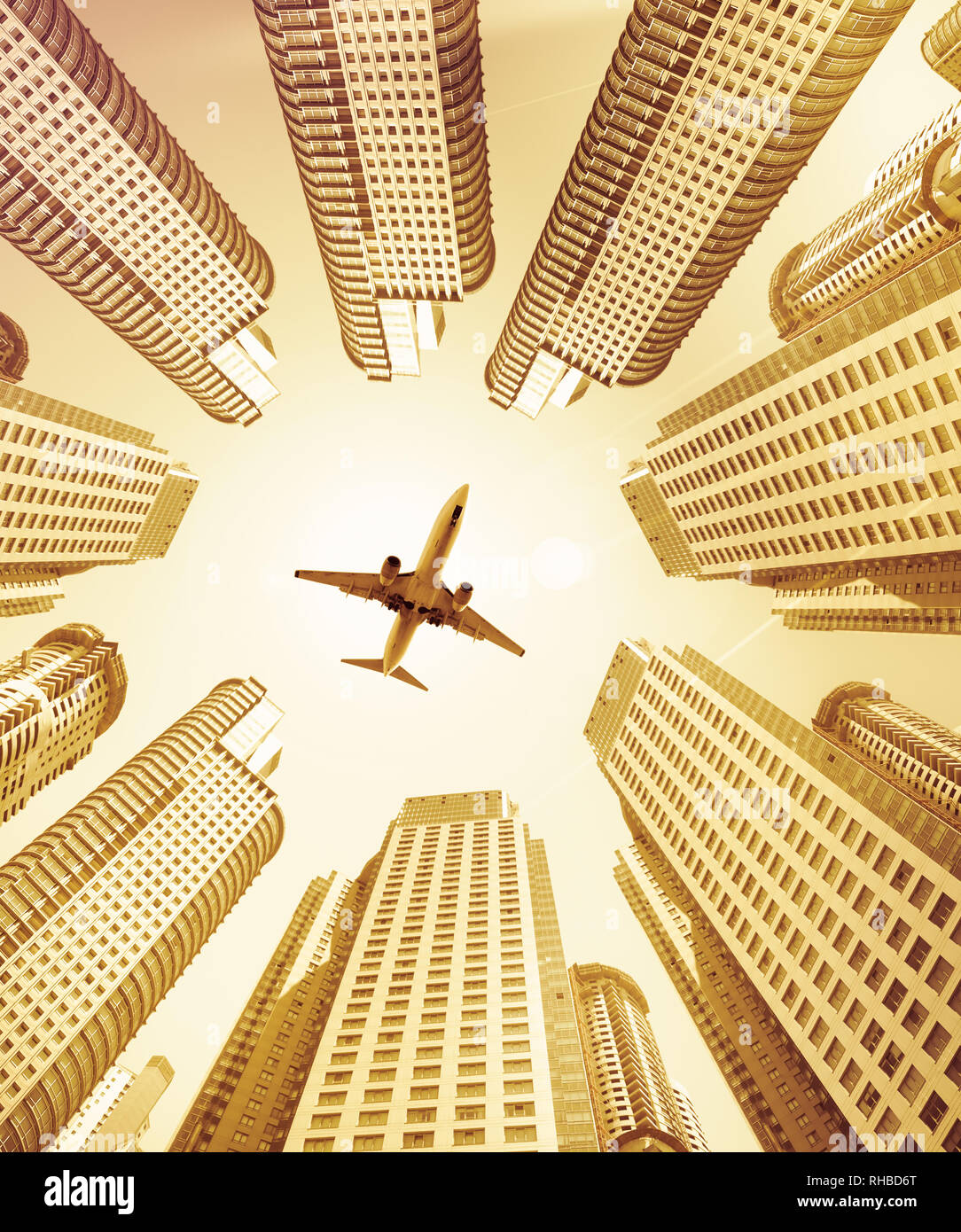 Airplane flying in the sky in the circle of buildings Stock Photo - Alamy