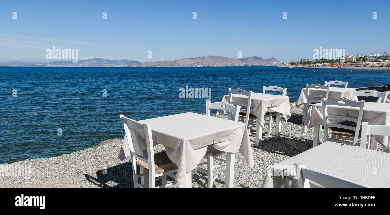 White restaurant tables on the beach in summer - travel, vacation and ...