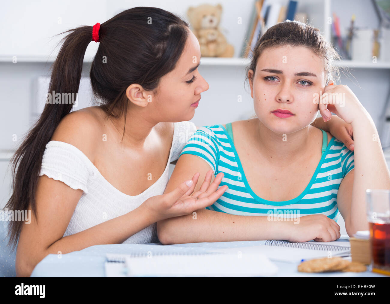Teenage girl calming her chagrined female friend Stock Photo - Alamy