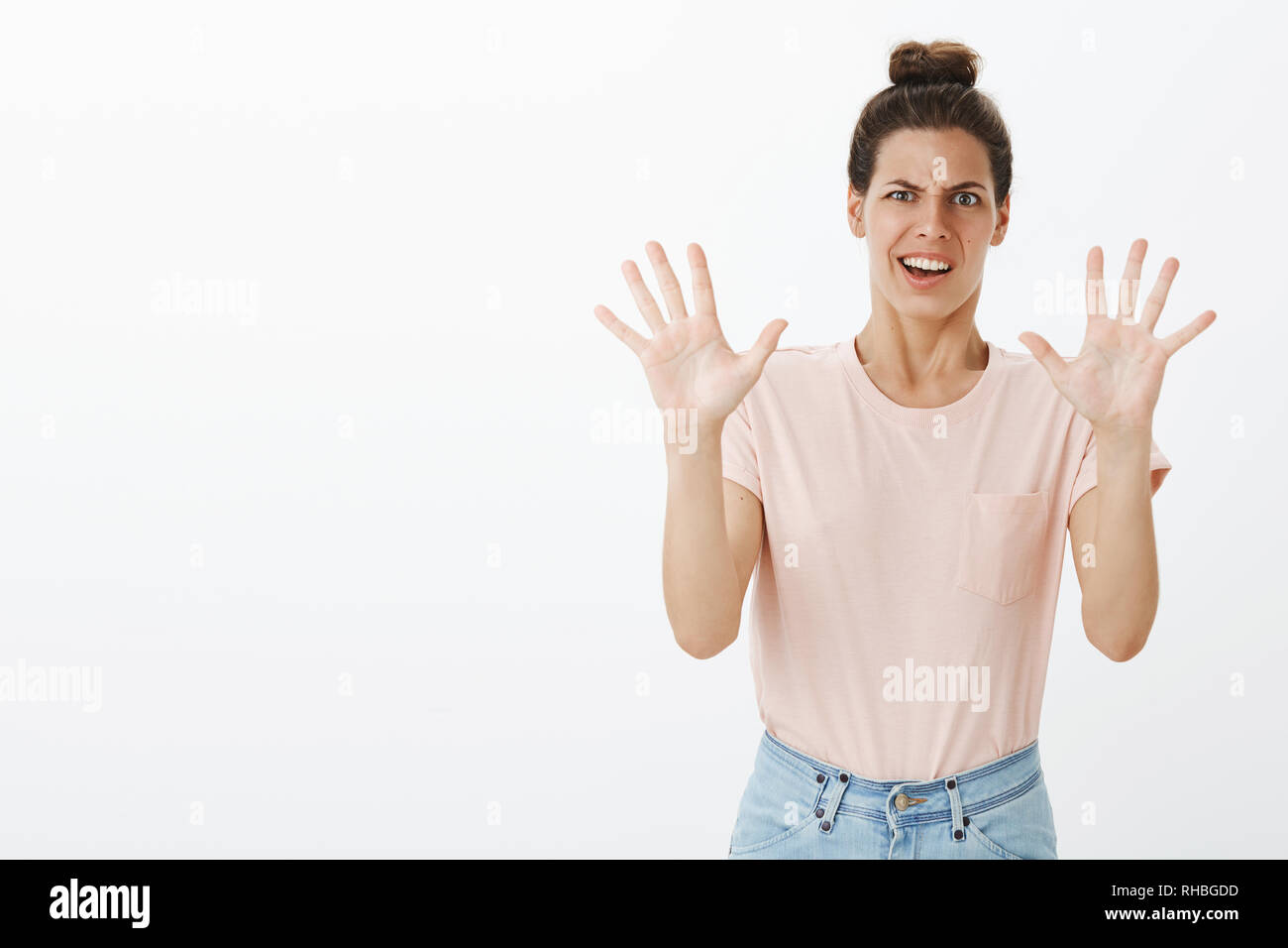 Displeased awkward and bothered young funny female with messy bun ...
