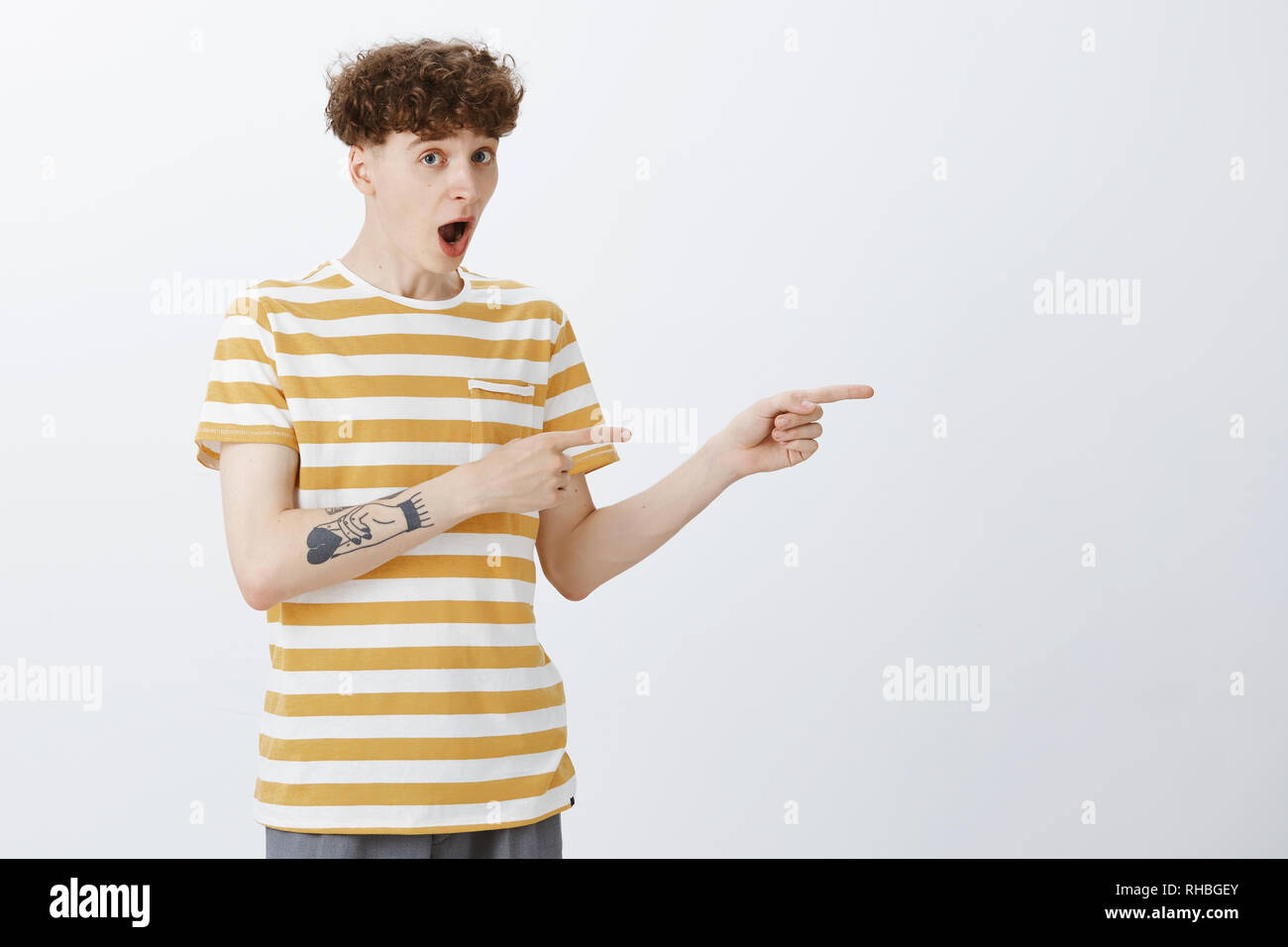 Hey man check it out. Portrait of amazed guy screaming omg as dropping ...