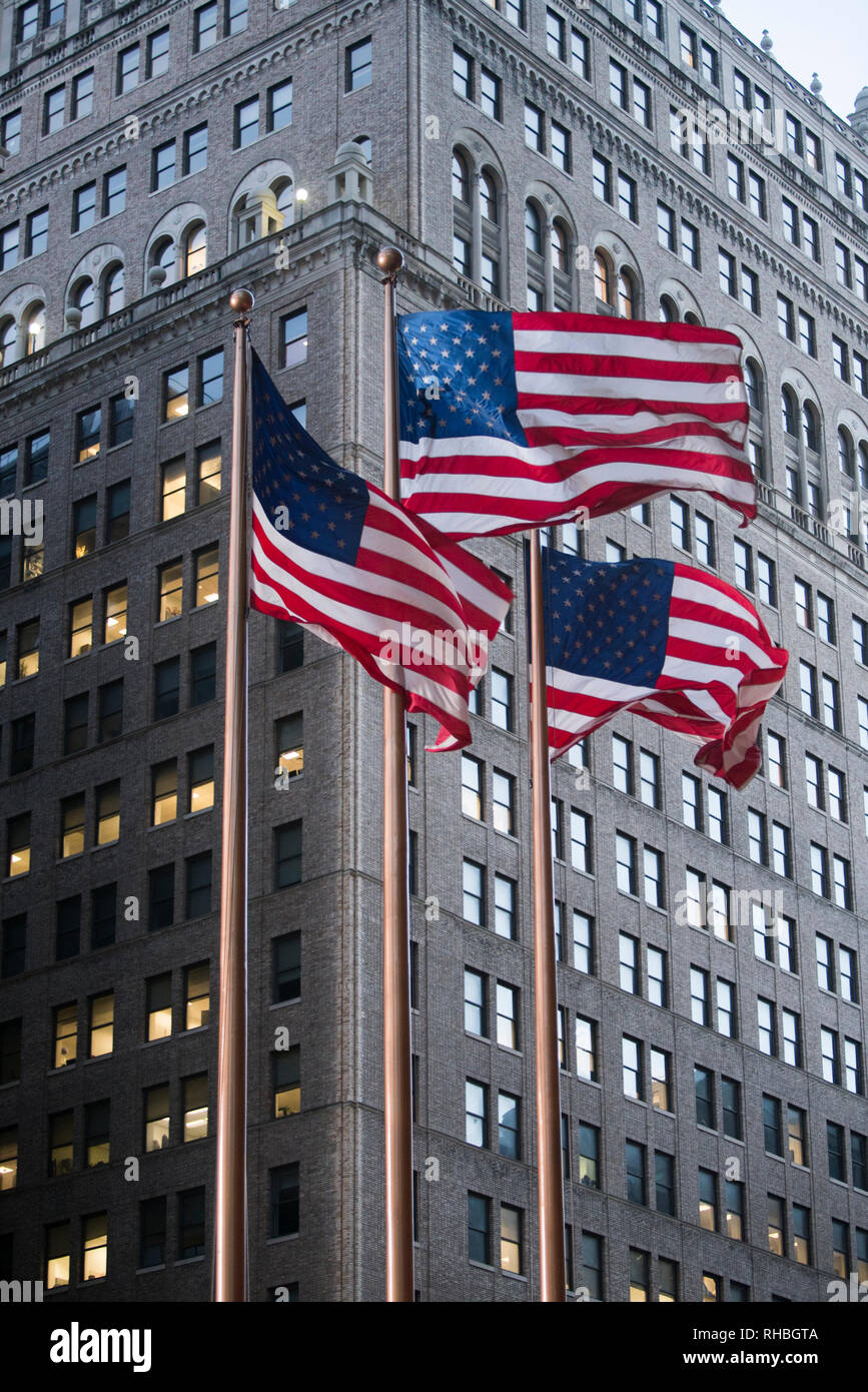 tall building in NYC with 3 flags waving in front Stock Photo - Alamy