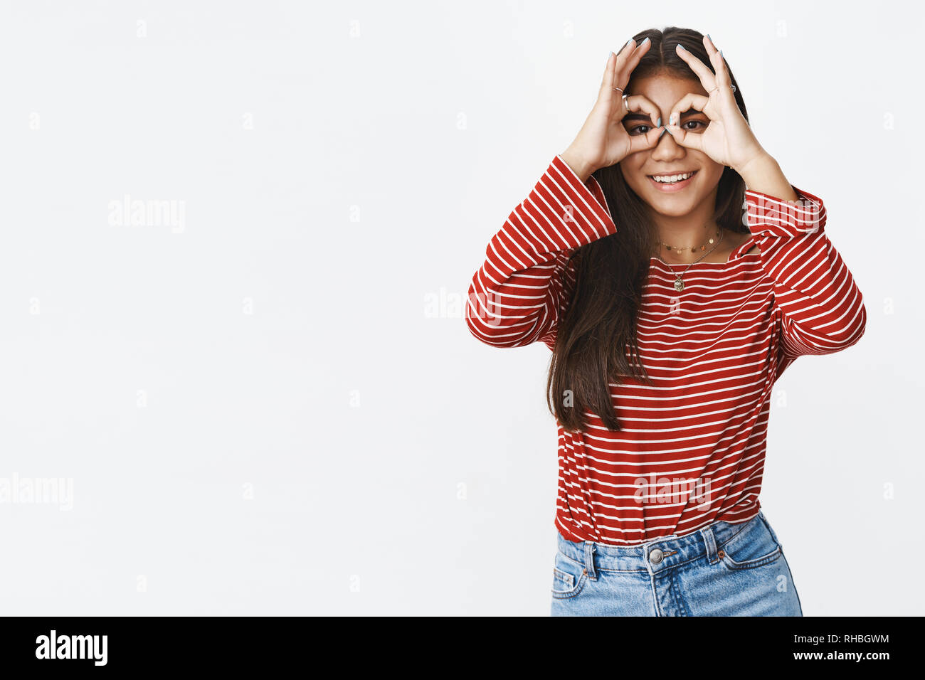 Studio shot of funny and playful young teenage girl with dark hair in ...