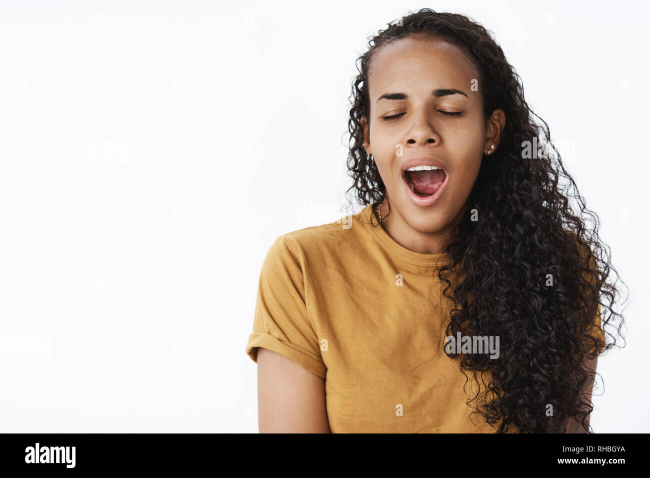 Waist-up shot of sleepy cute african-american female getting up in ...