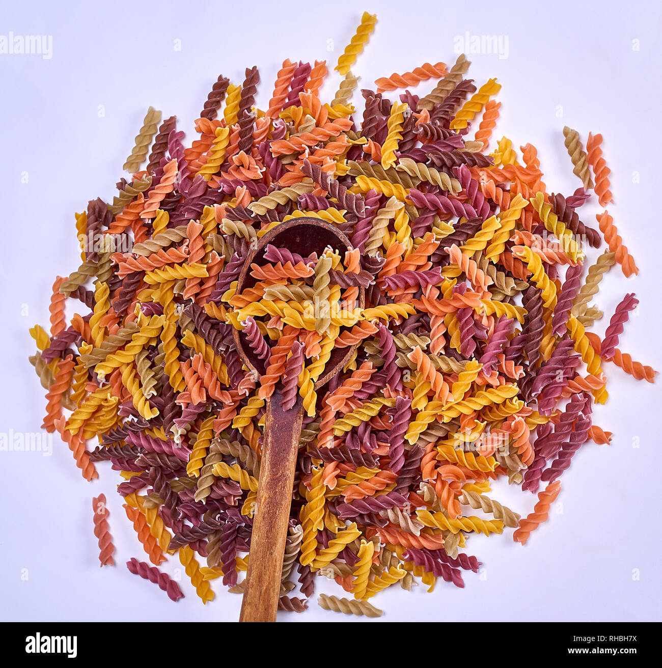 uncooked pasta colorful spiral fusilli made from wheat flour on a white ...