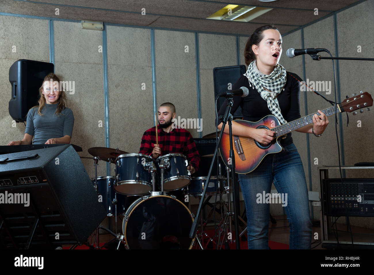 Portrait of active excited young girl rock singer with guitar during ...