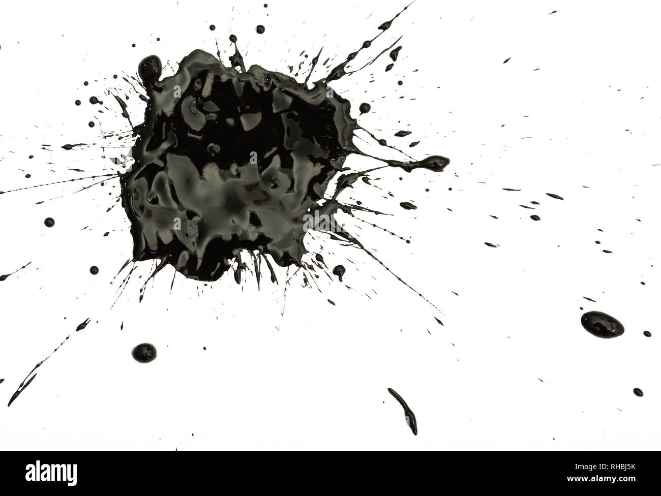 Splash and splatters of spilled paint of black color on white surface ...