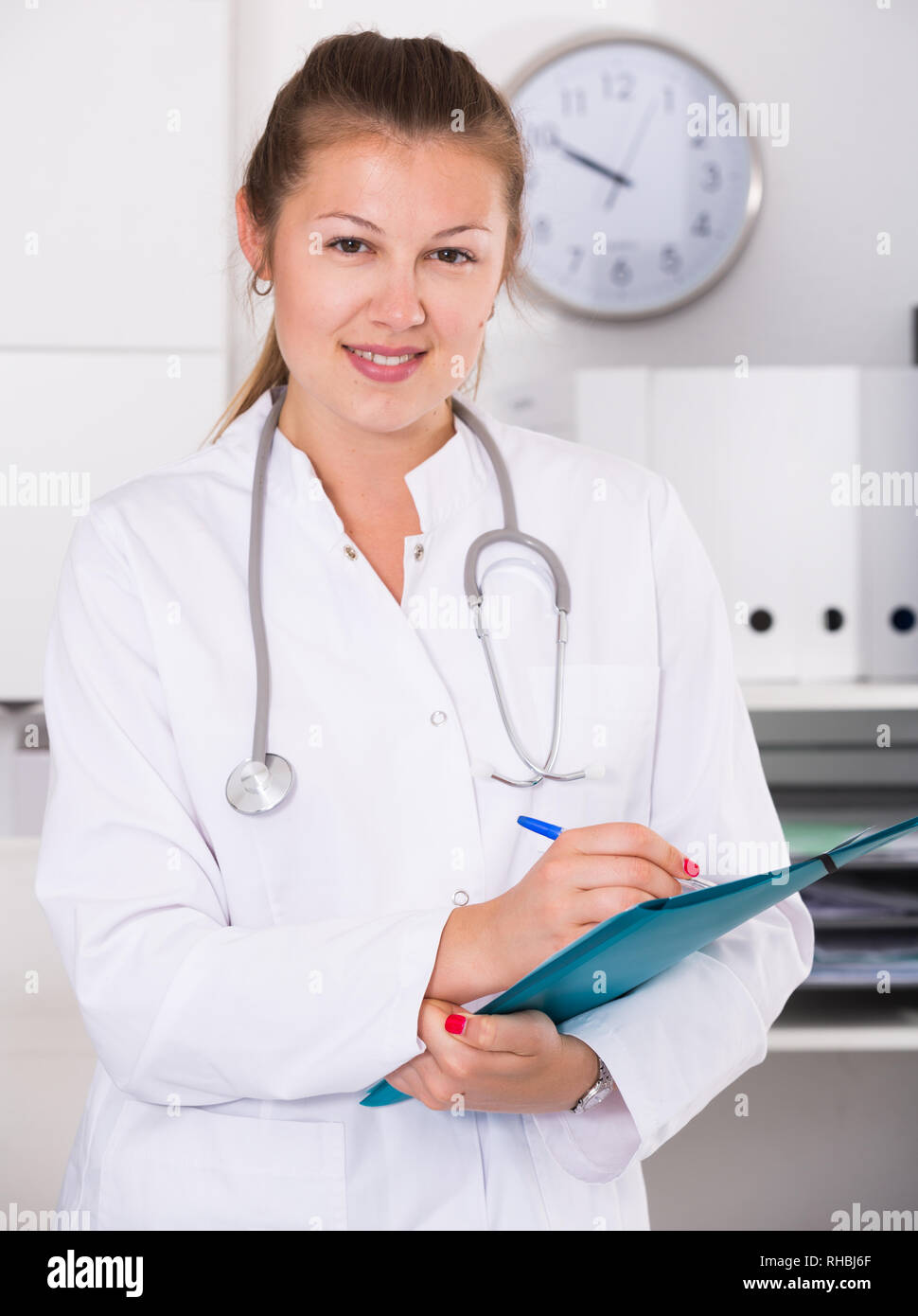 Young doctor female is signing patient`s diagnosis in clinic Stock ...