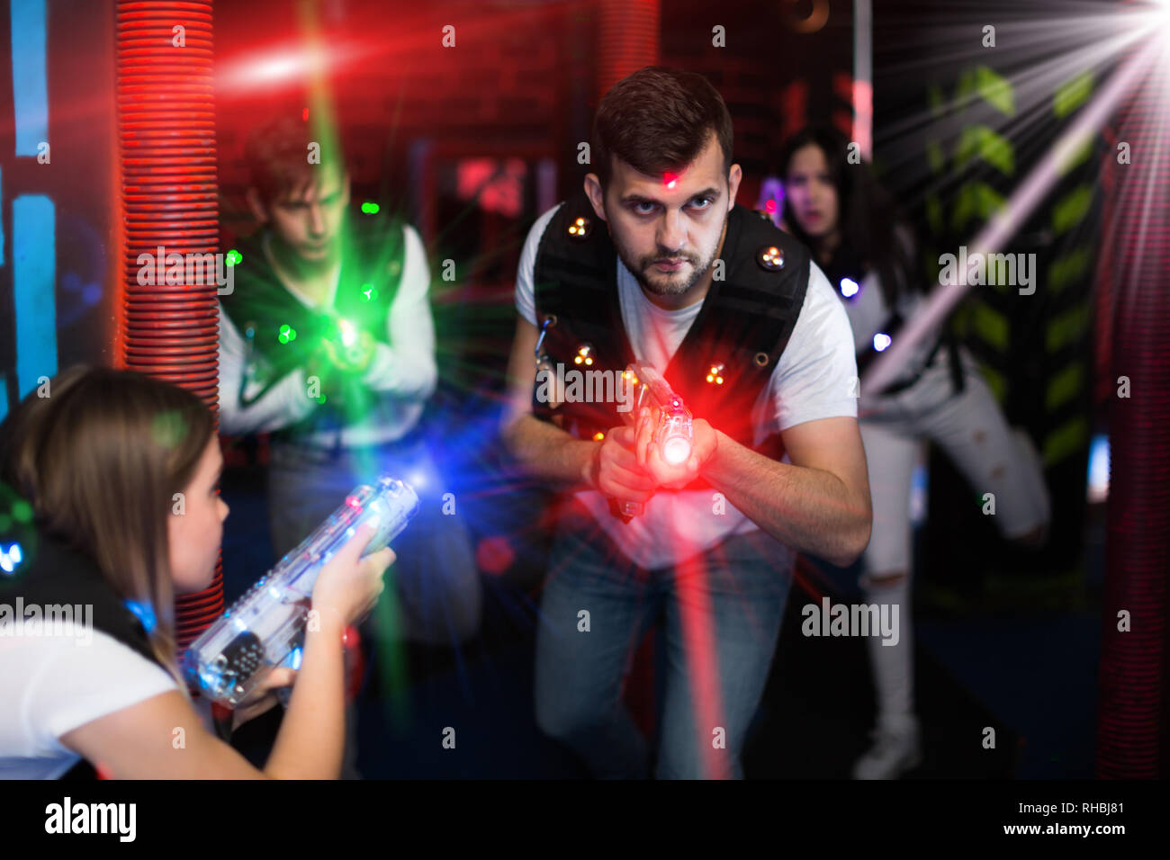 Portrait of excited guy laser tag player with laser pistol in room with ...