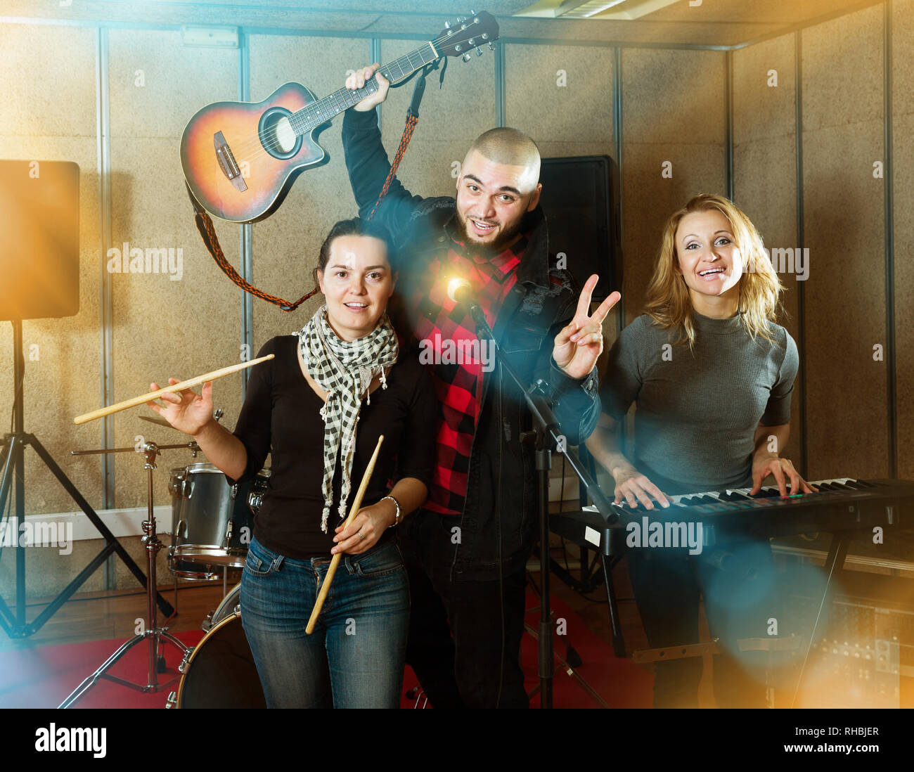 Portrait of expressive happy group of rock musicians posing with ...