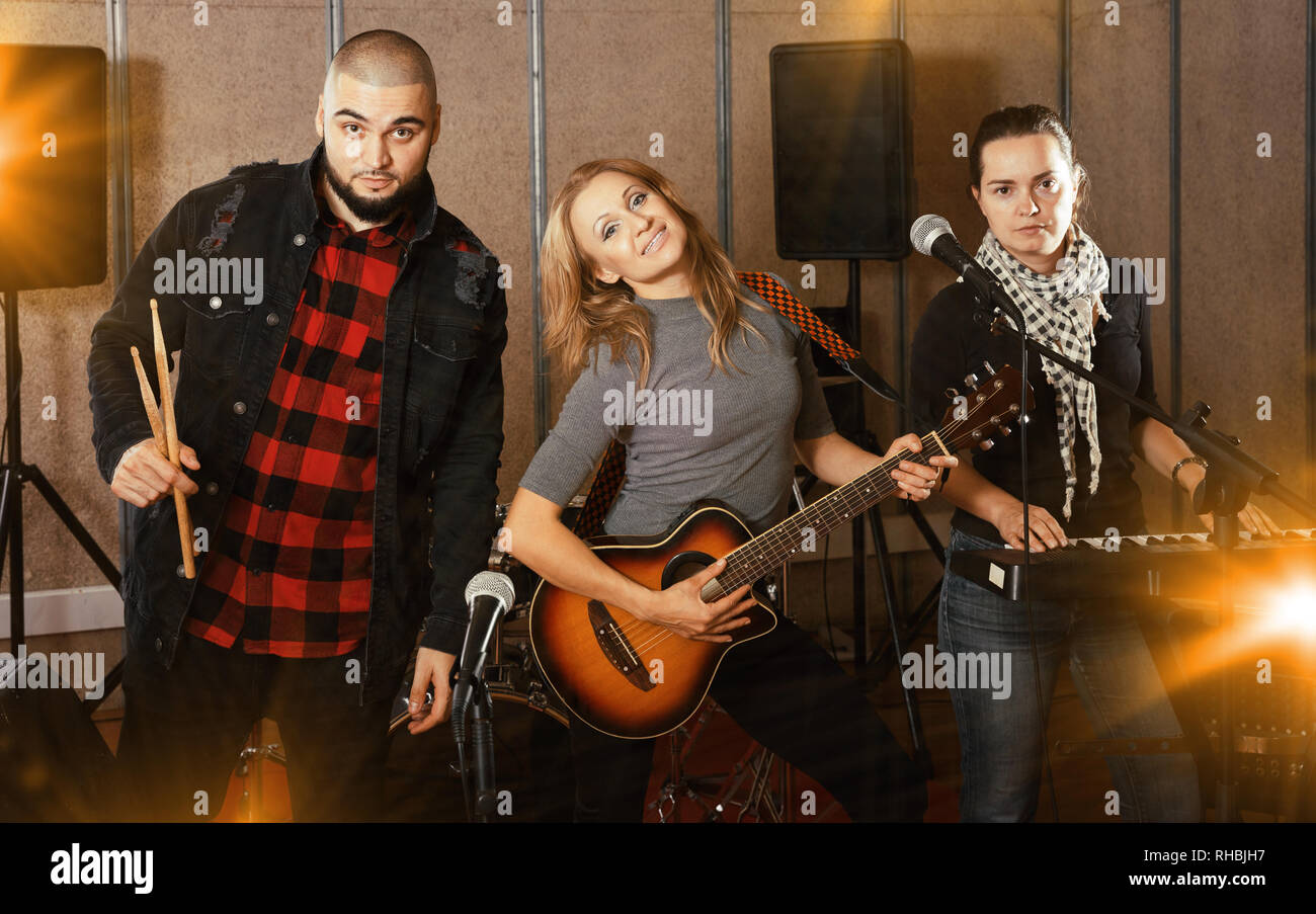 Expressive toung group of rock musicians posing with instruments in ...