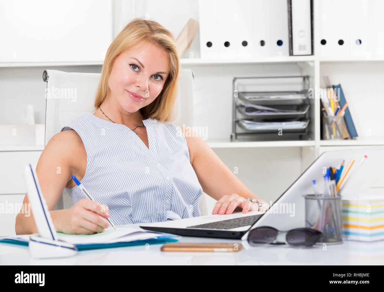 portrait of adult russian business female employee writing and working ...