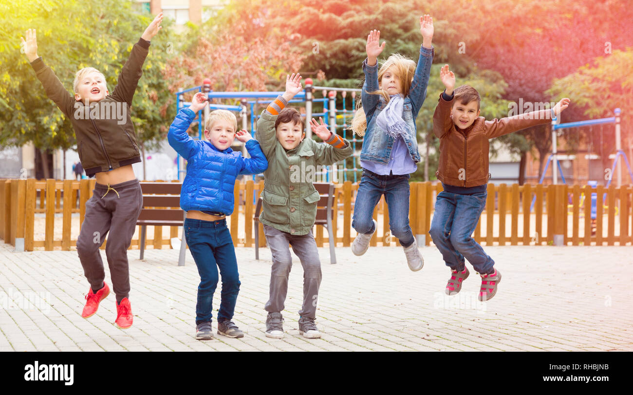 Group of laughing happy children jumping together on playground Stock ...