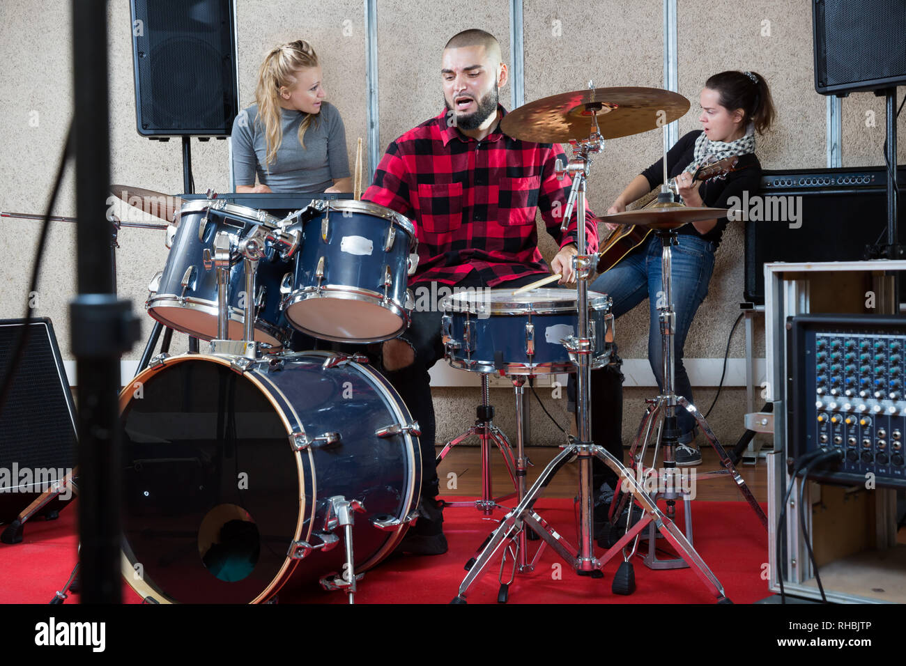 Rehearsal of a music group. Rock band with emotional male drummer ...