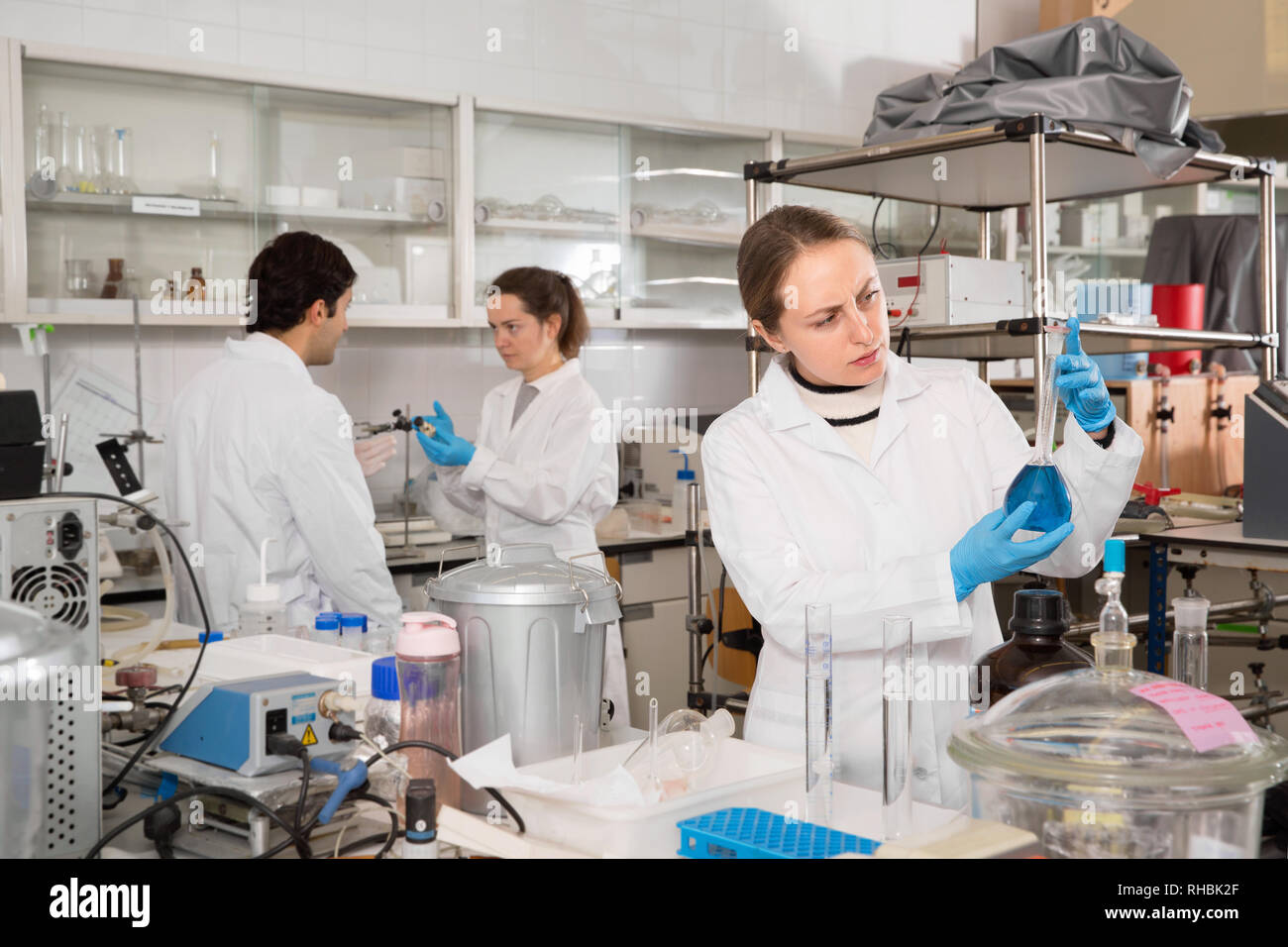 Young diligent efficient female lab technician working with reagents in ...