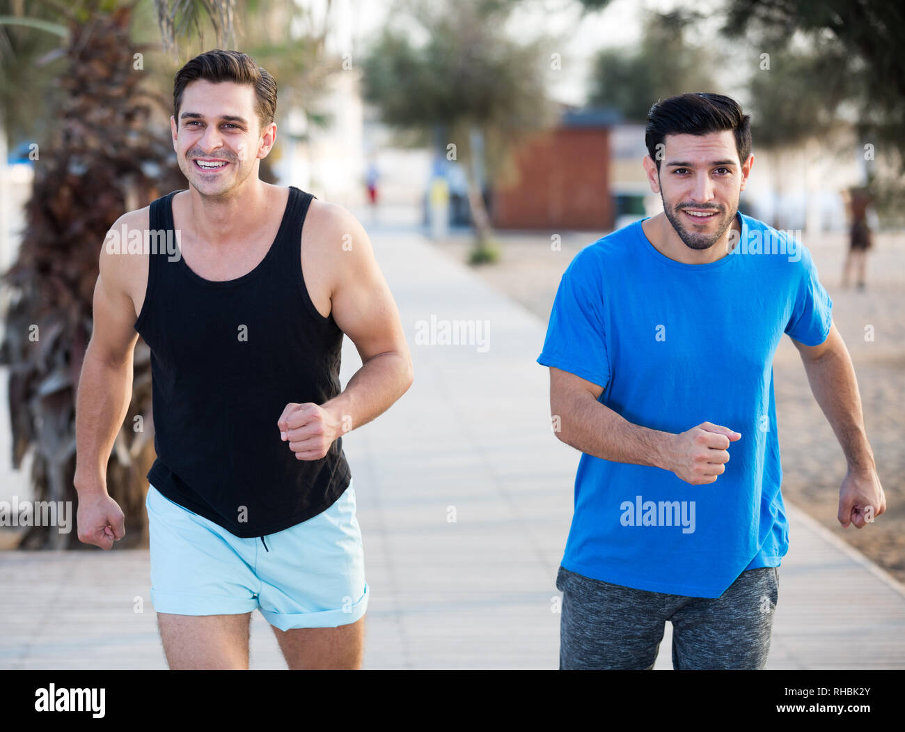 Adult men are jogging together in the park near ocean Stock Photo - Alamy