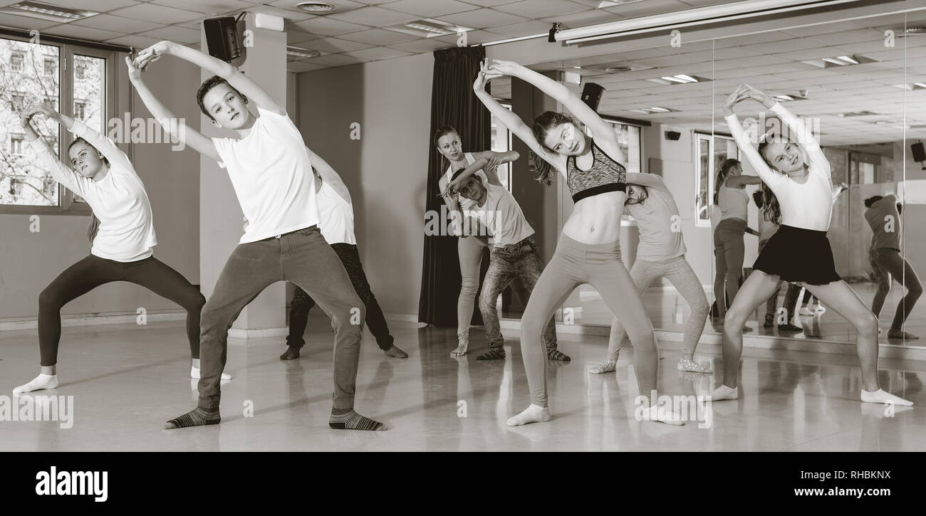 Children dancing synchronous group choreography with female coach in ...
