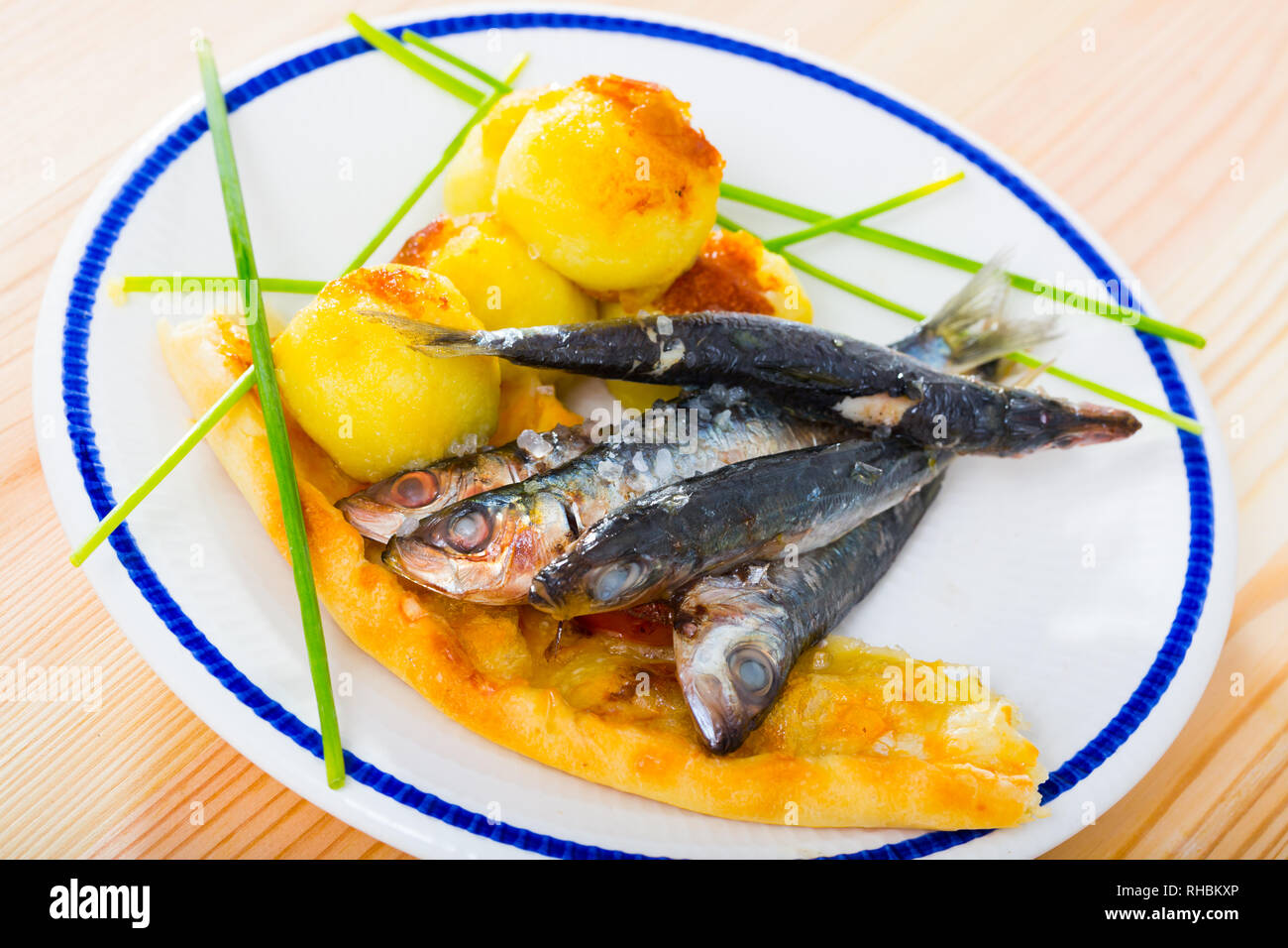 Dish of tasty fried anchovy with potato croquettes and cake served on ...