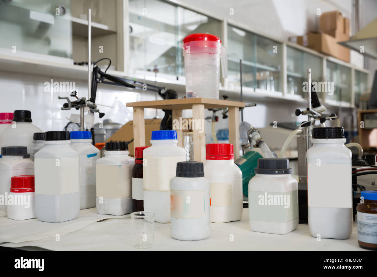 Plastic jars with various chemicals on desktop in research laboratory ...