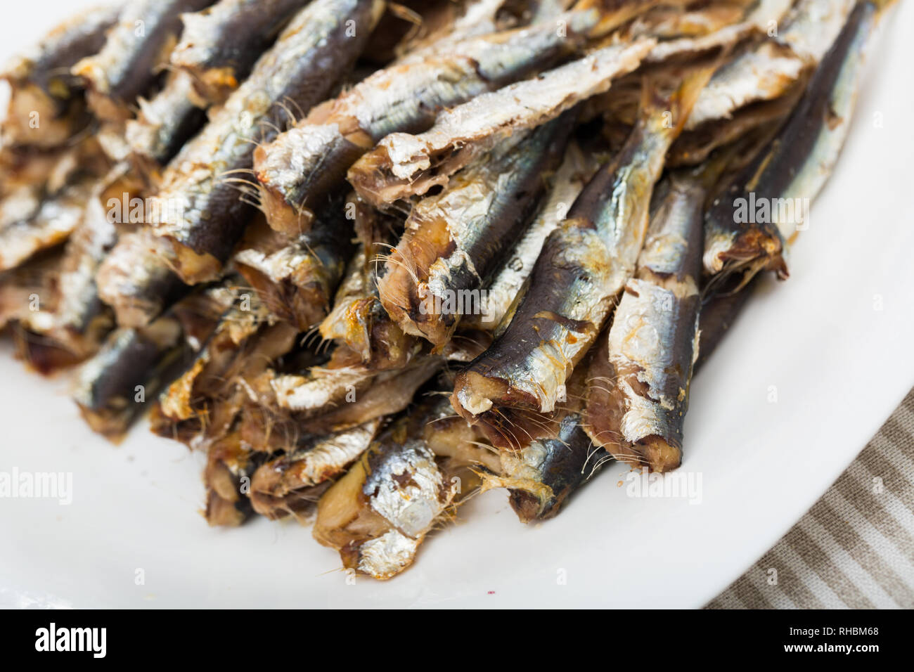 Seafood. Appetizing baked sardines served without garnish on white ...